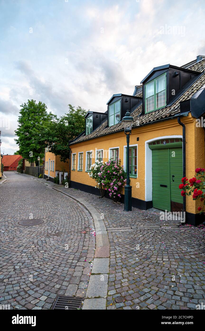 Yellow cottages along a cobblestoned street in historic old town of ...