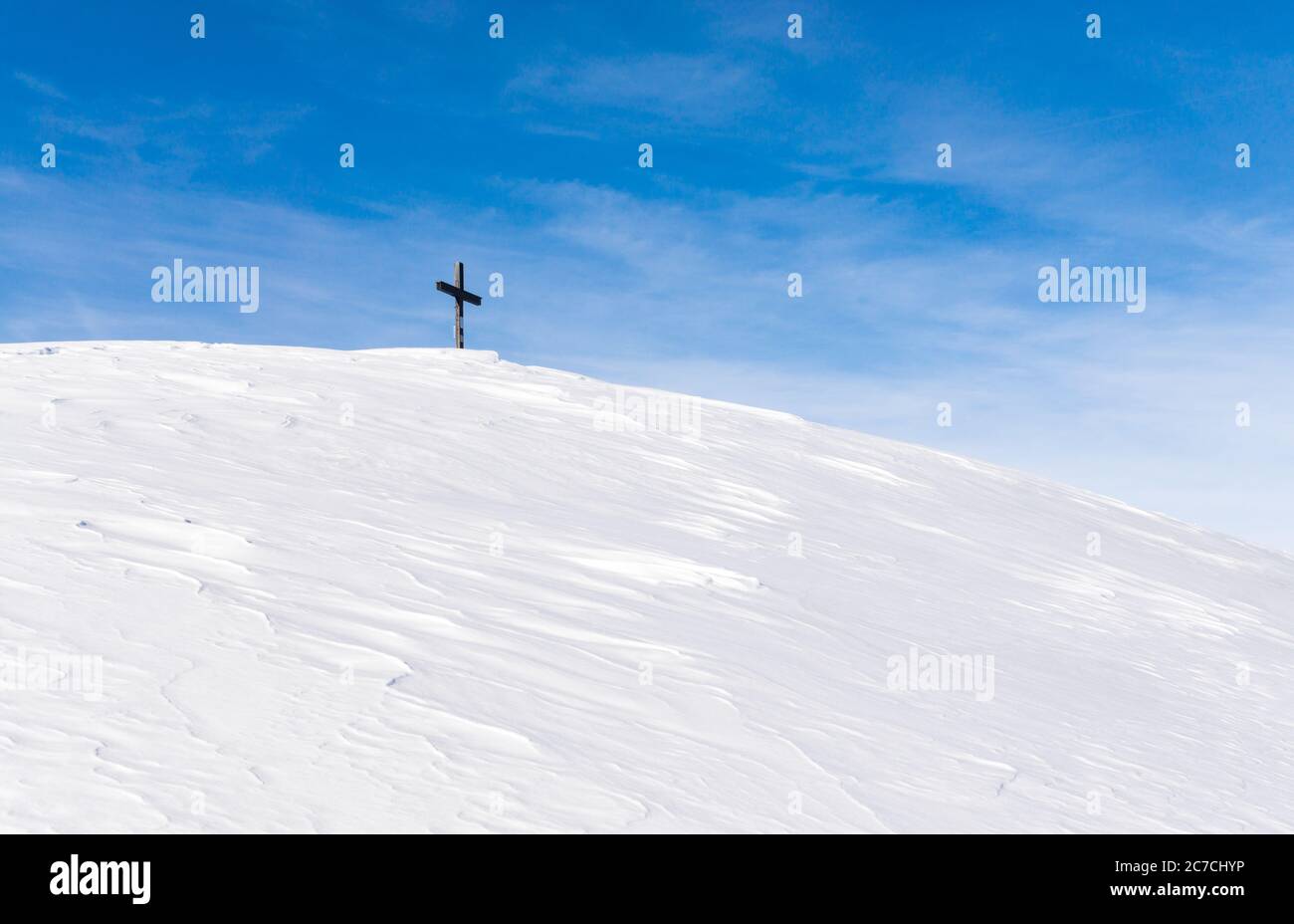 Lonely Summit Cross on windswept snow mountain with blue Sky ...