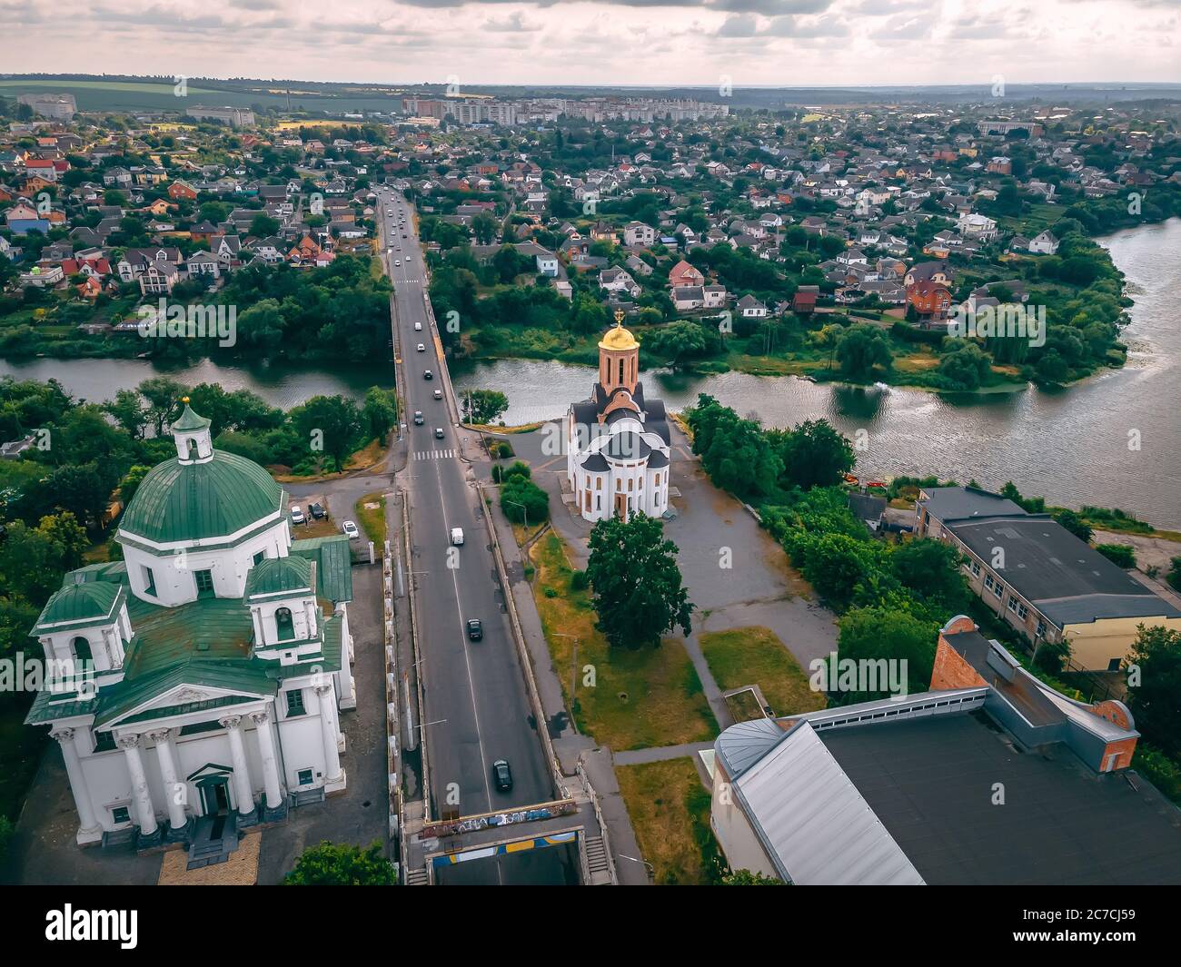 Aerial view of two old churches near river and bridge in small european ...