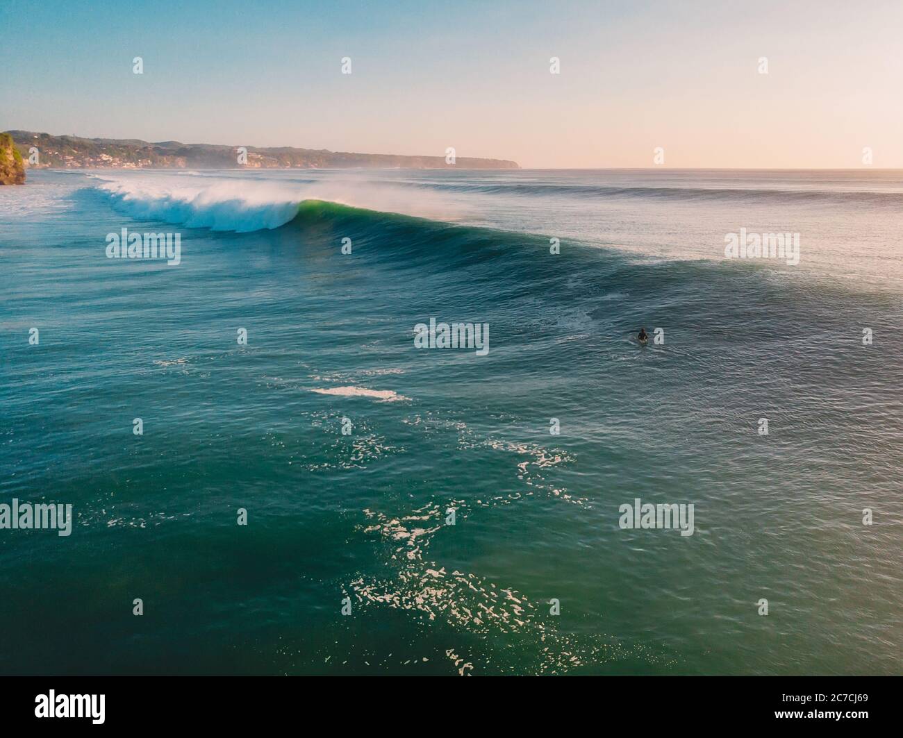Aerial view of big stormy waves and surfer at sunset time. Biggest ...