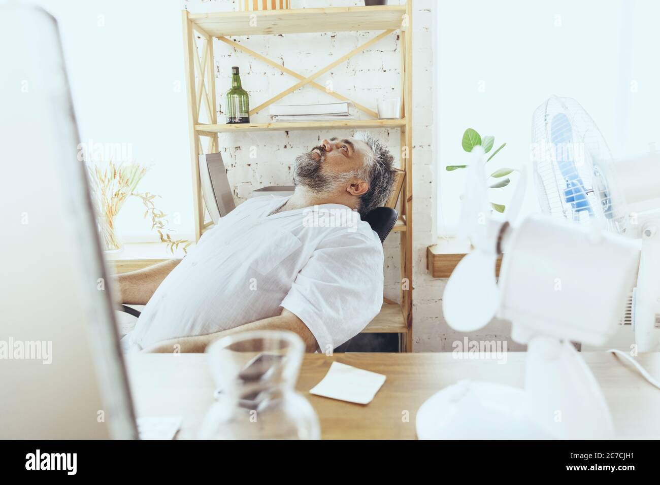 No rescuing. Businessman, manager in office with computer and fan ...