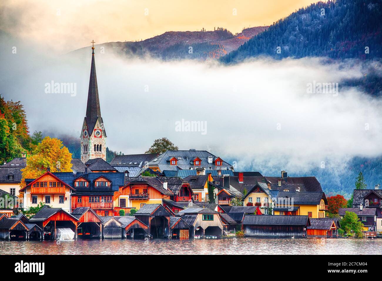 Scenic view of famous Hallstatt mountain village with Hallstatter lake. Foggy autumn sunrise on ...