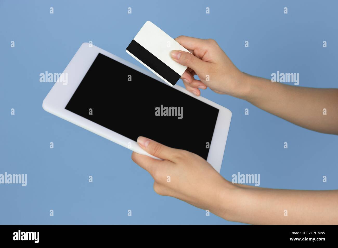 Female hands with debit, credit card and tablet with copyspace on blank ...