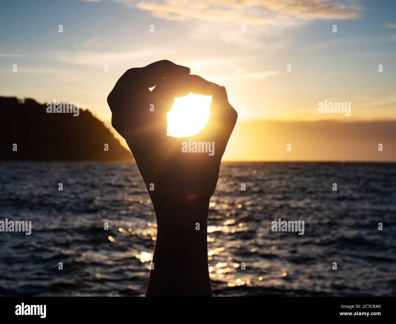 Silhouette of shadow shape being made by hands with sunlight on beach ...