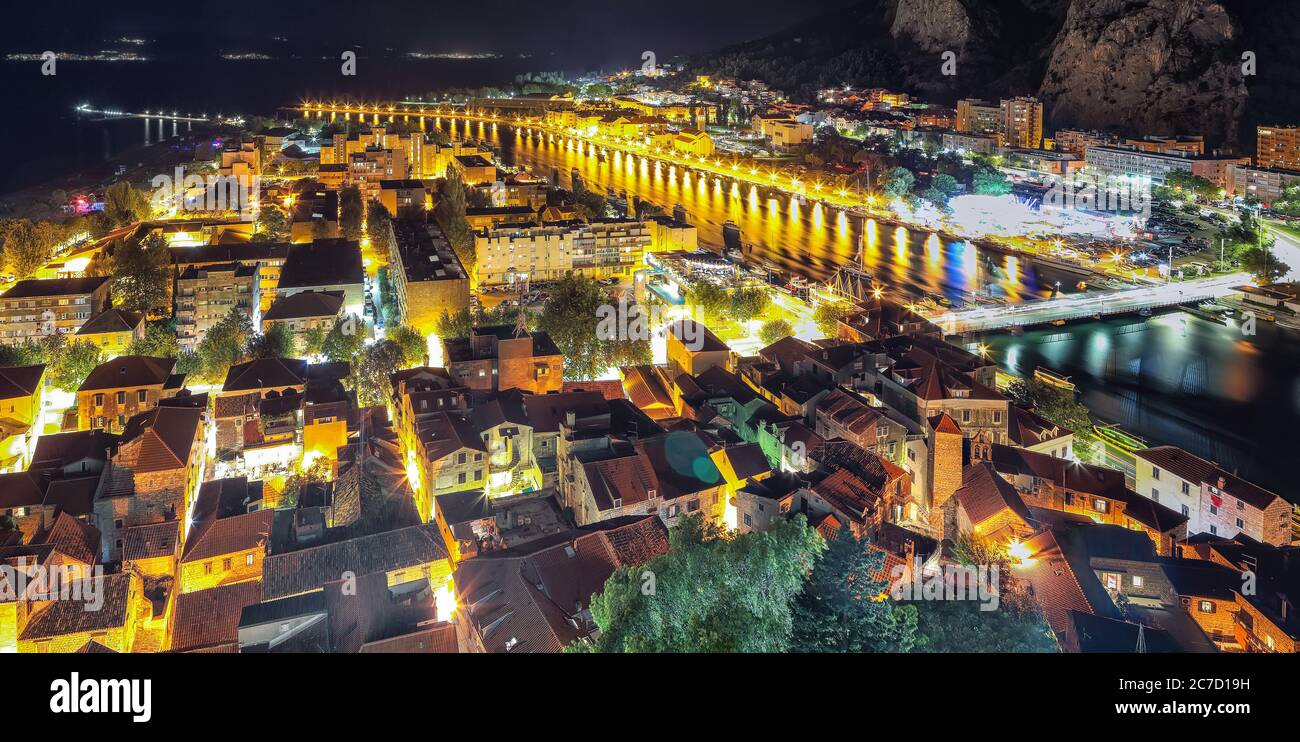 Wonderfull aerial panoramic view of Old Town Omis , Cetina river and mountains at night ...