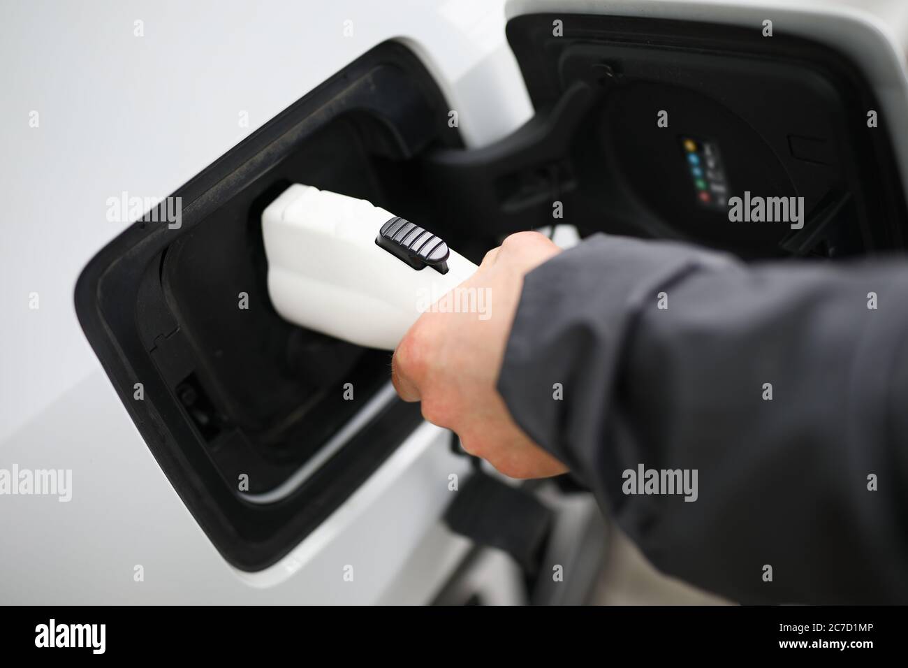 Man puts his electric car on charge closeup Stock Photo - Alamy