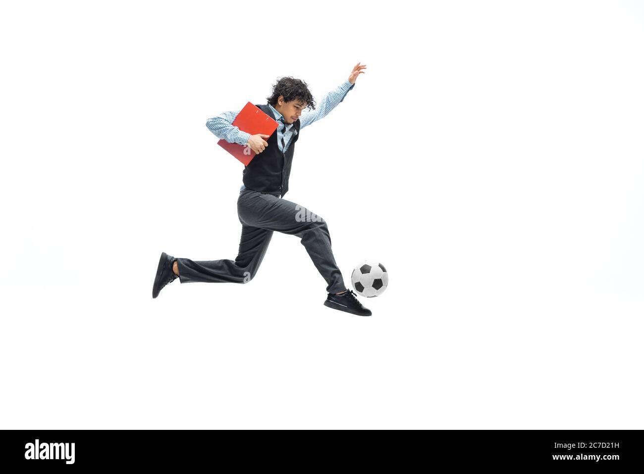 Man in office clothes playing football or soccer with ball on white ...