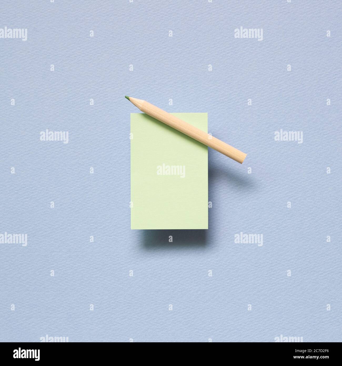 Green memo paper, sticky notes with colored pencil on blue background ...