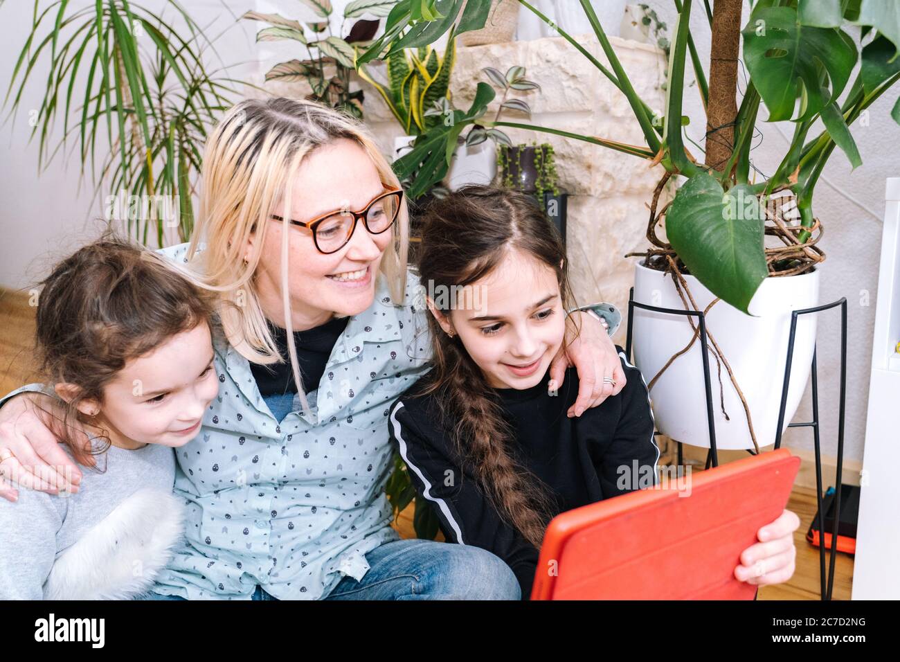Woman with children sitting at home and holding videocall. Family using ...