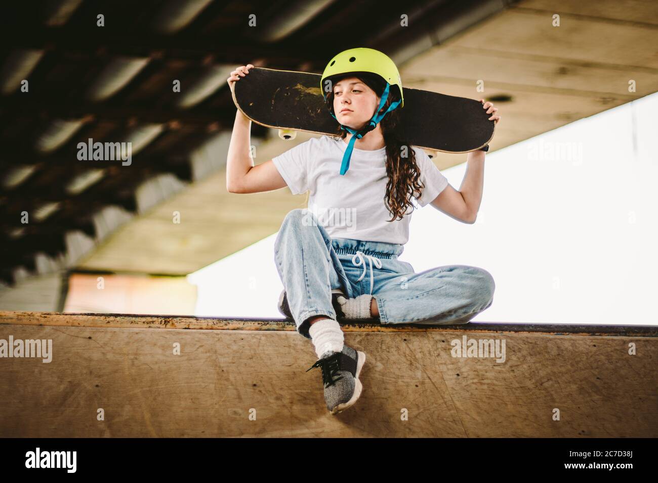 Schoolgirl after lessons at skateboarding practice in outdoor skate ...