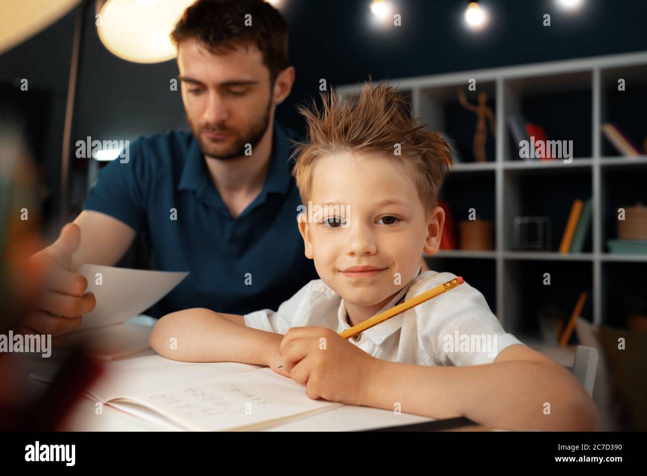 Dad and son doing school homework together Stock Photo - Alamy