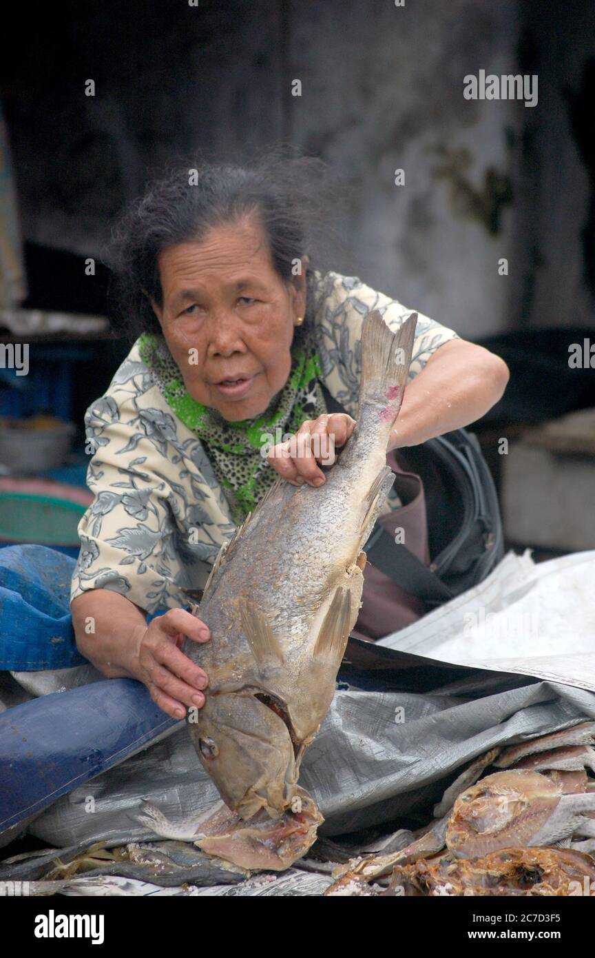JAKARTA, INDONESIA - Mar 07, 2014: old woman fish monger holding big ...