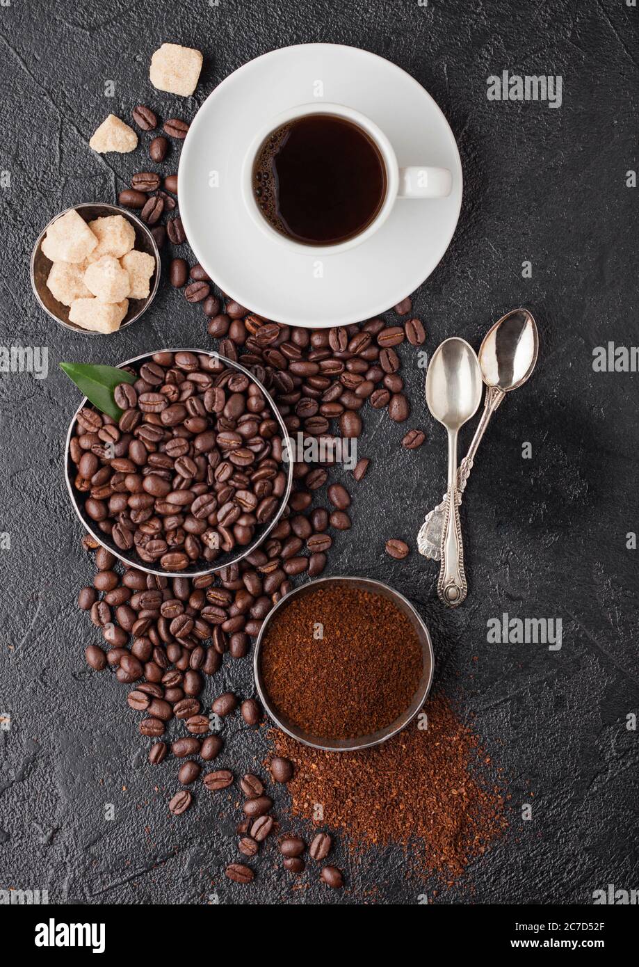 White cup of fresh raw organic coffee with beans and ground powder with ...