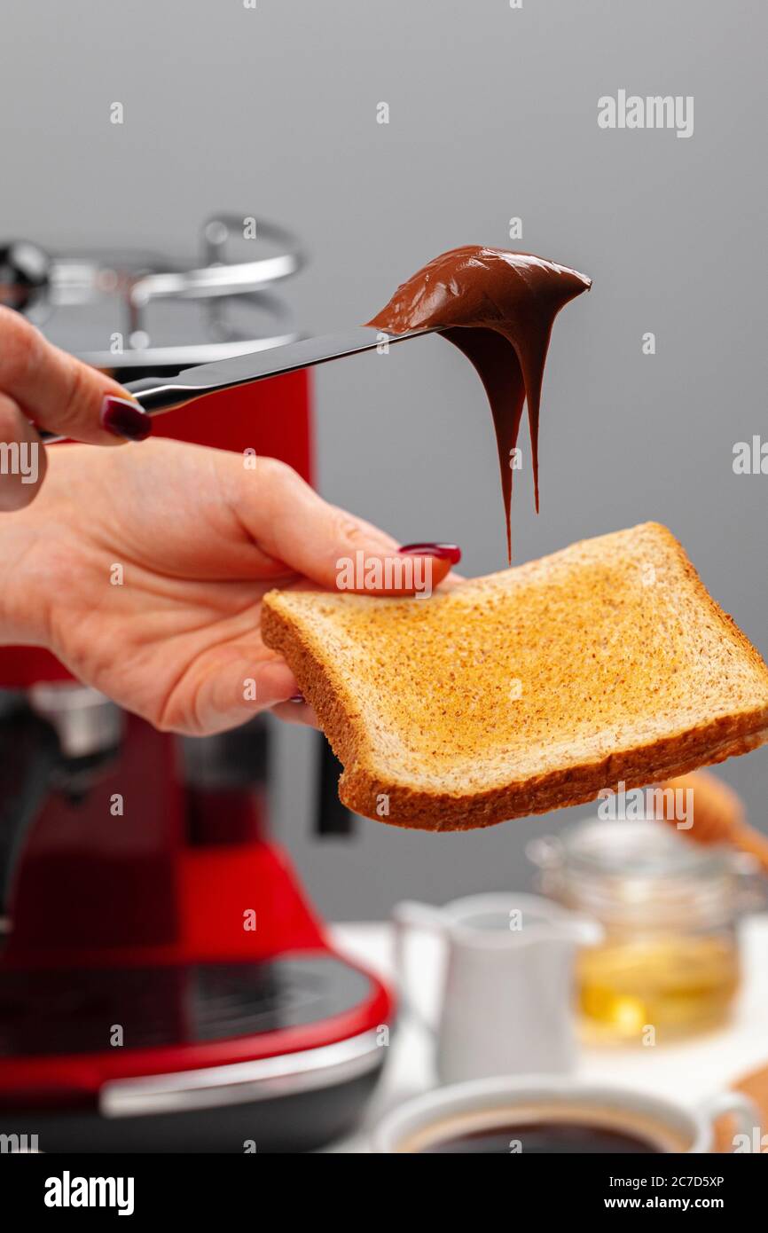 Female hand cooking toast with chocolate paste Stock Photo - Alamy