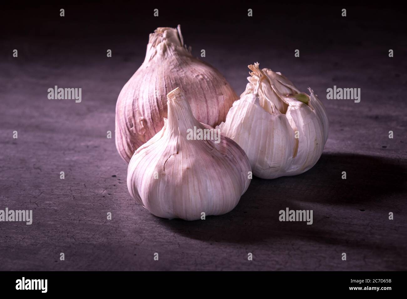 three large heads of pink garlic on a kitchen worktop Stock Photo - Alamy