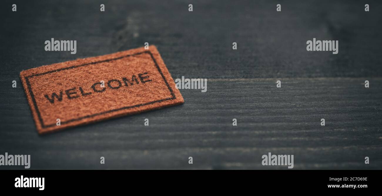 Old Welcome door mat on black wooden background, welcome concept, home ...
