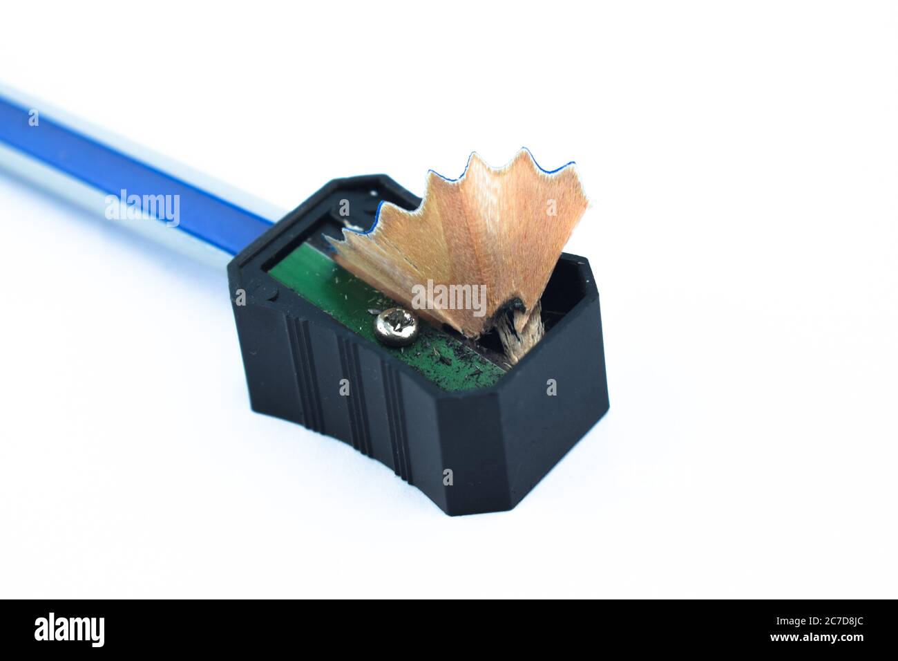 Sharpening a blue colored wood pencil crayon with a black colored ...