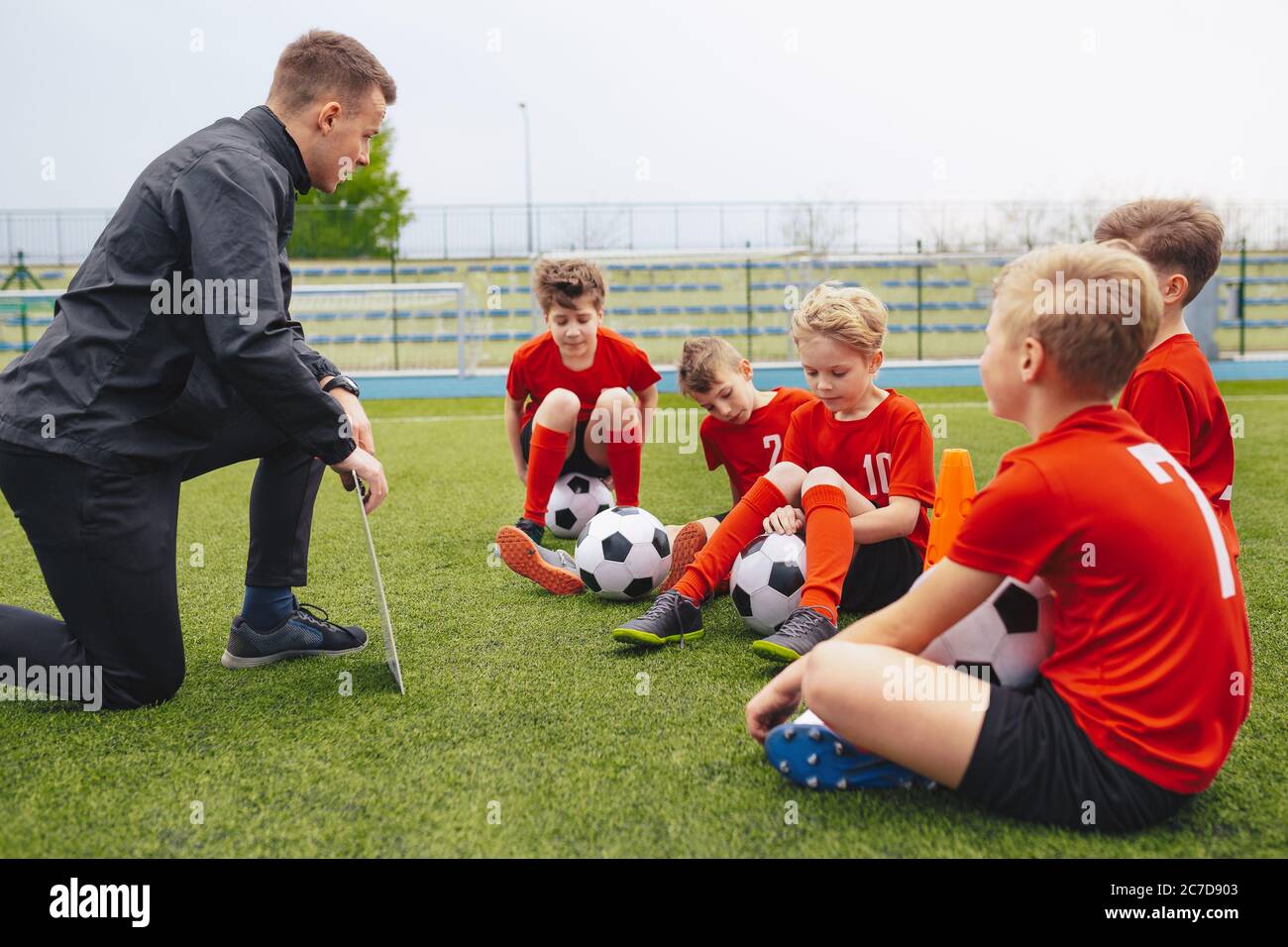 Group of sad boys with coach after loosing soccer tournament match ...