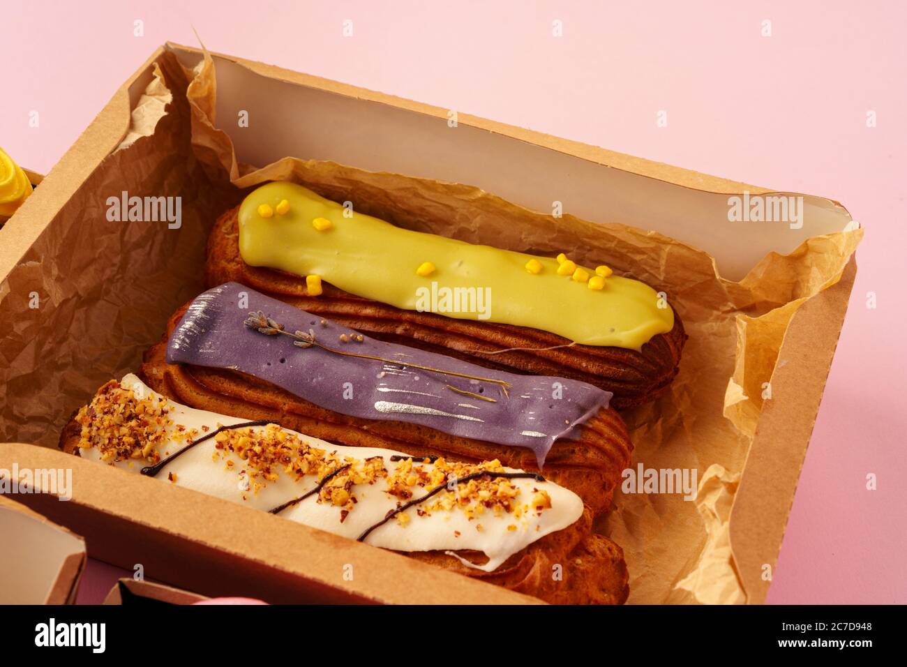 Box with fresh eclairs on pink background Stock Photo - Alamy