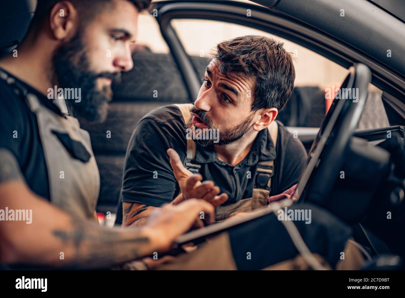 Two people. Mechanics working in repair service Stock Photo - Alamy