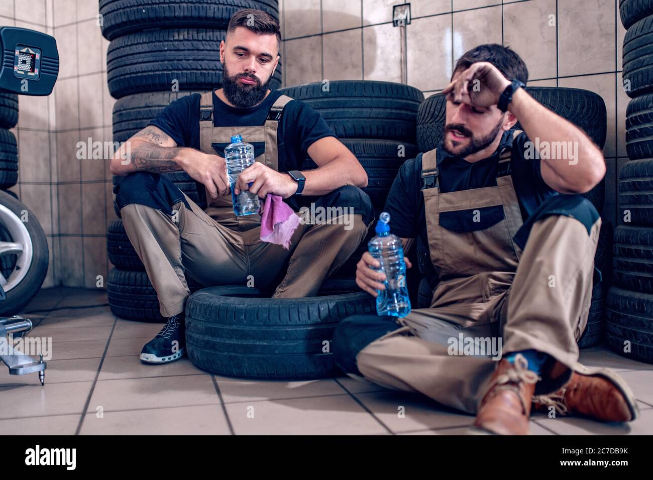Two people. Mechanics resting after hard work,they changing tires Stock ...