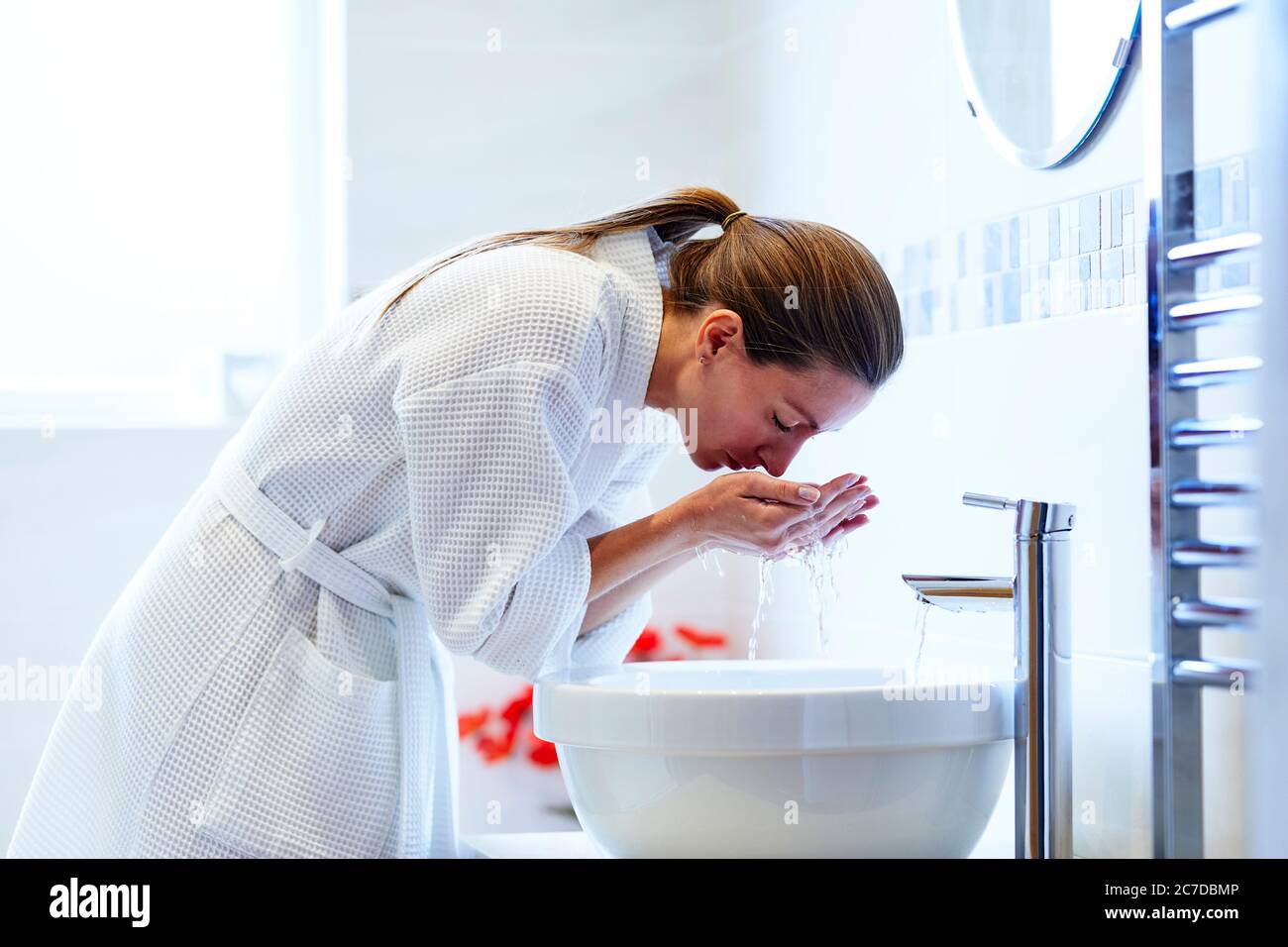 Beautiful woman washing her face in the bathroom Stock Photo - Alamy