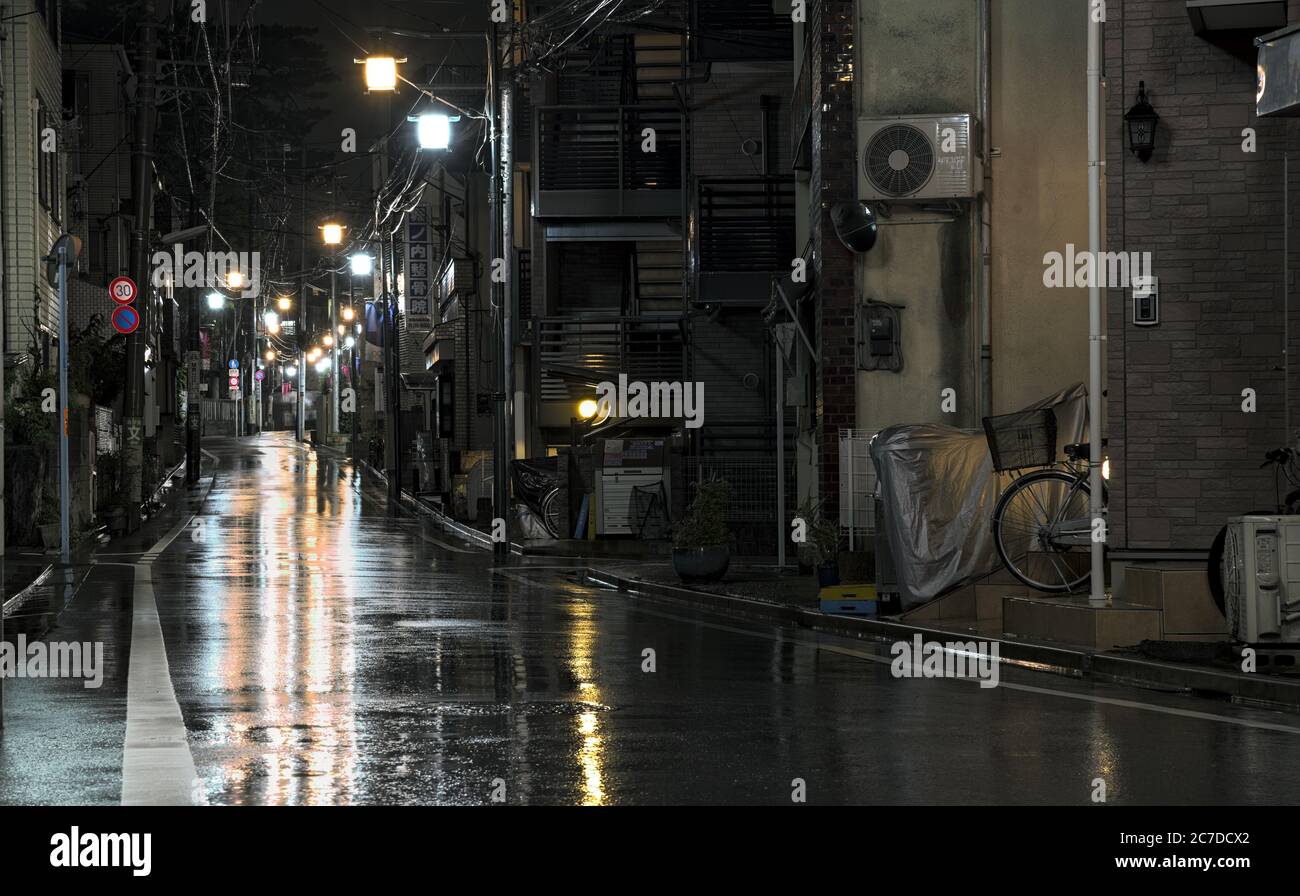 Night view of an empty rain-soaked street illuminated by streetlamps in ...
