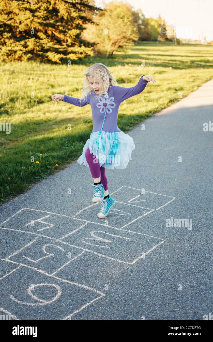 Cute adorable little young chld girl playing hopscotch outdoor. Funny ...