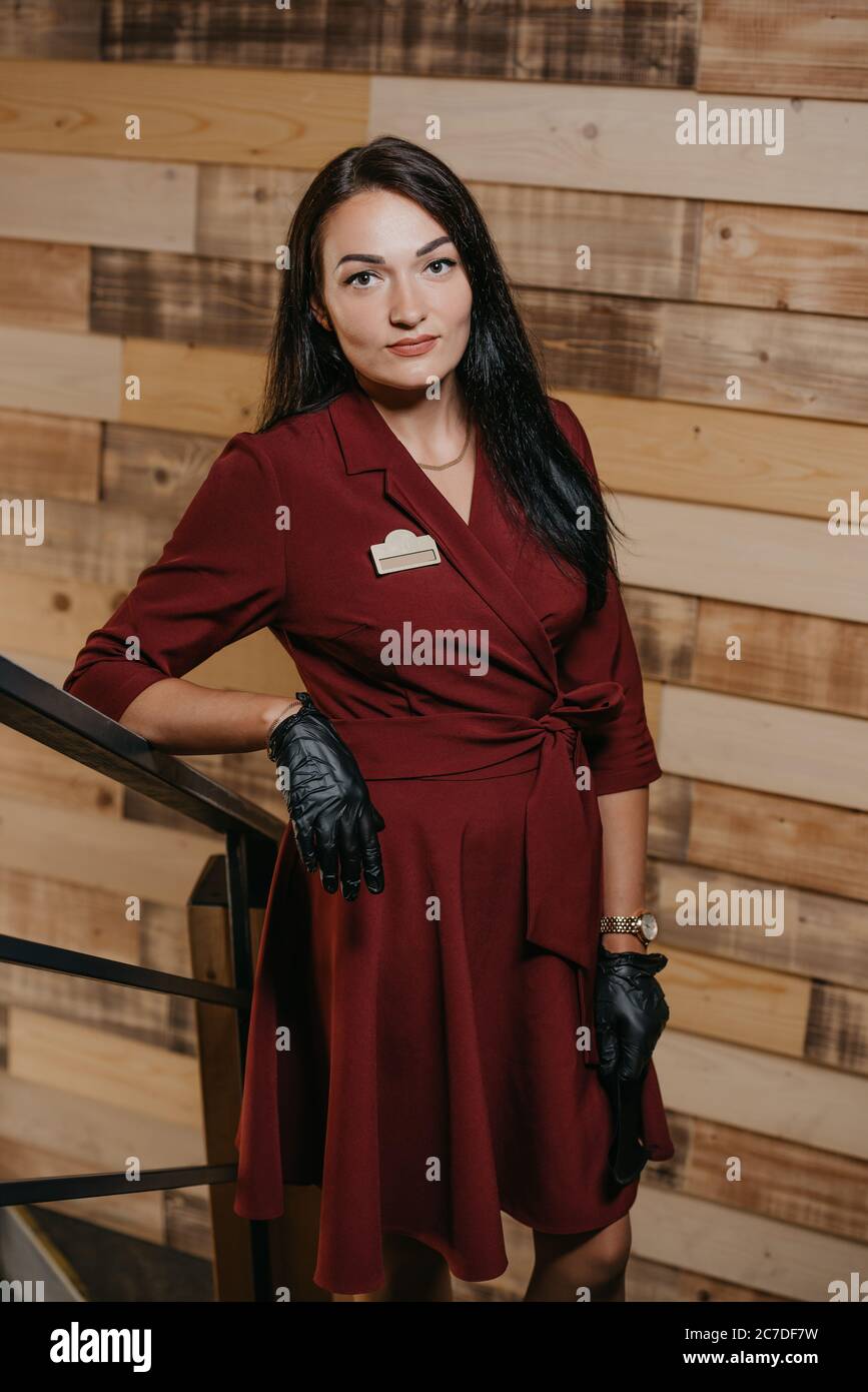 A gorgeous female restaurant manager in black disposable gloves who is ...