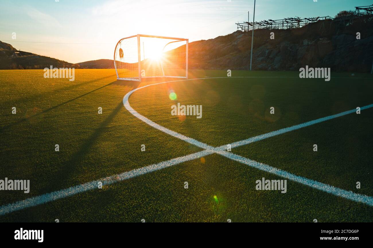 Wide shot of a football pitch with the sun rays under the beautiful ...