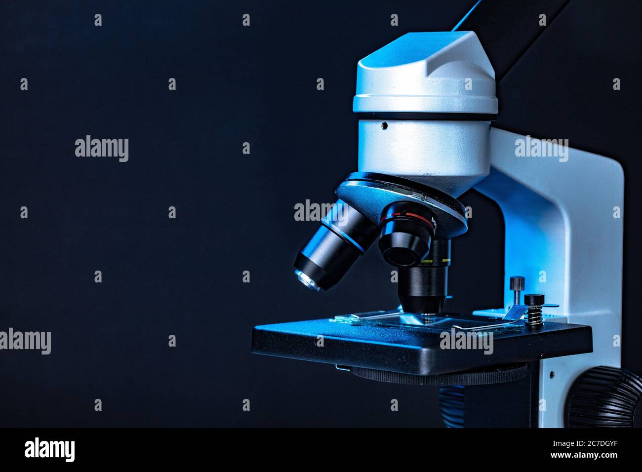 Microscope with lenses close up against dark background Stock Photo - Alamy