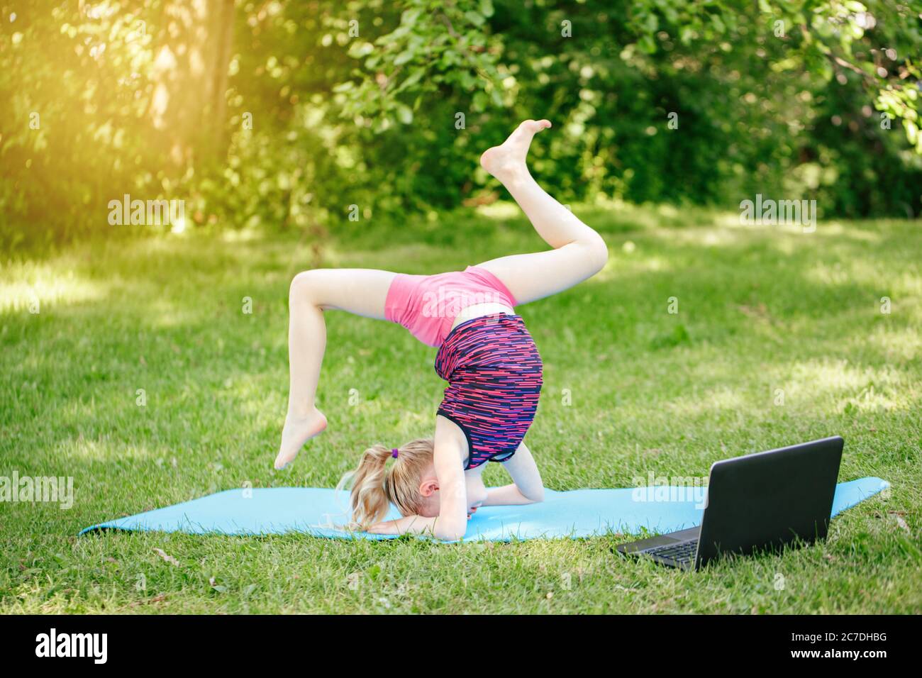 Girl child doing sport workout outdoor online. Video yoga stretching on ...