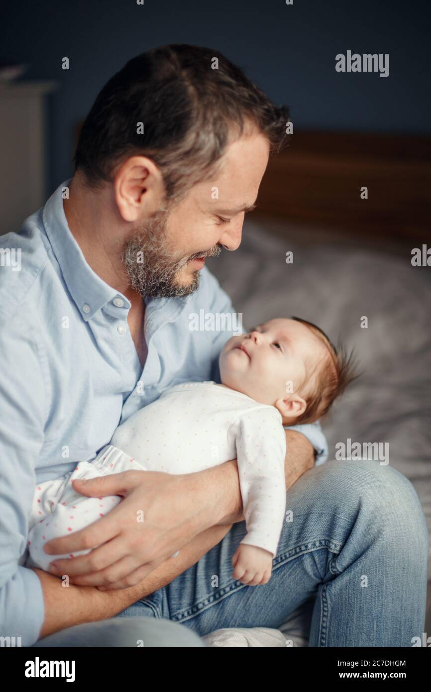 Middle age Caucasian father with sleeping newborn baby girl. Parent ...