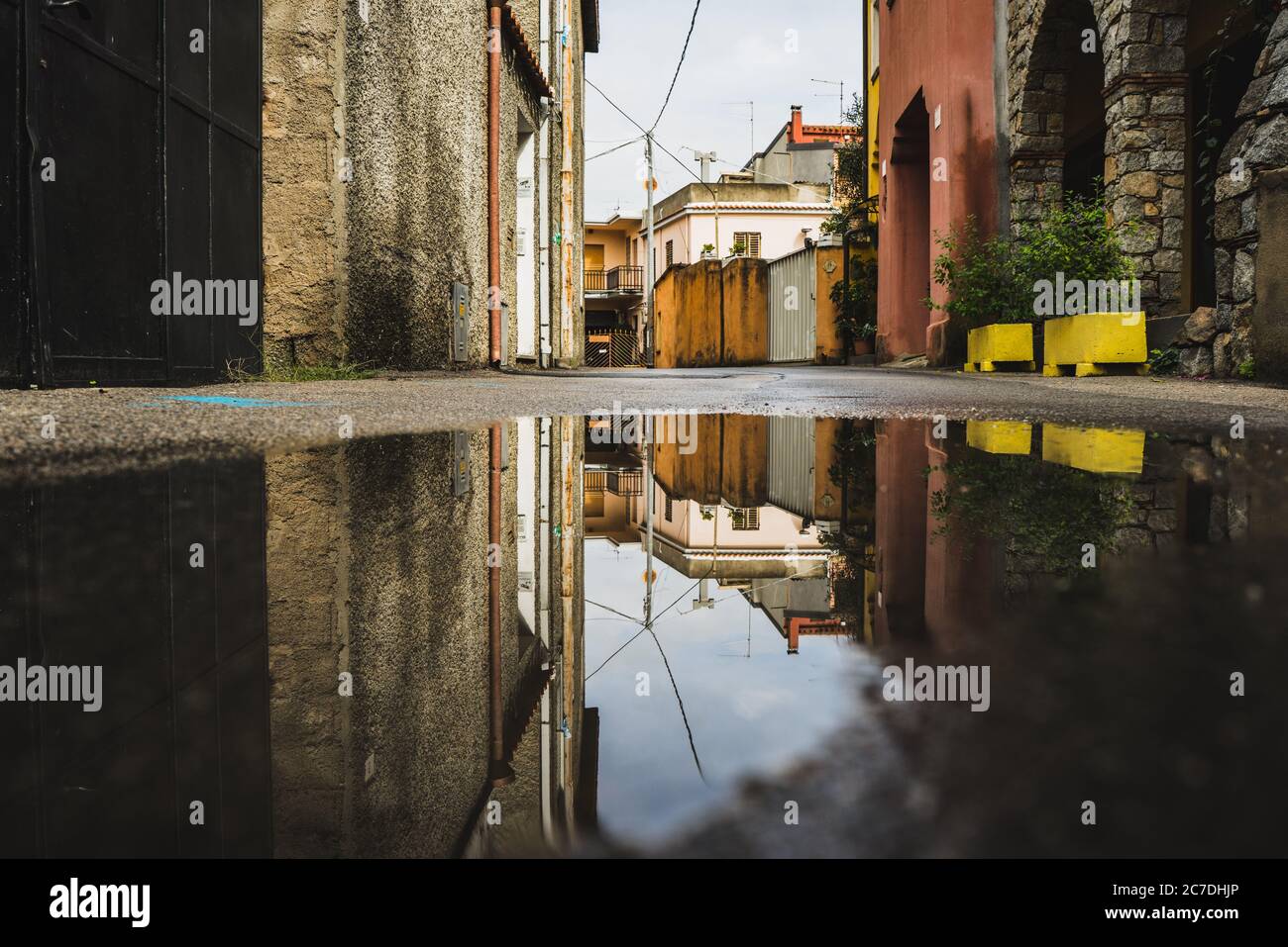 Worm's-eye shot of an alley's reflection in a water puddle Stock Photo ...