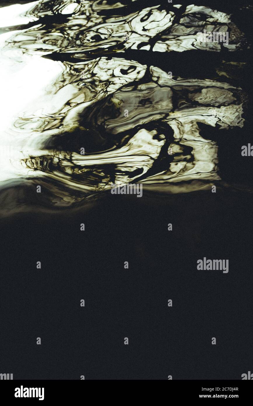 Vertical closeup of a watery surface with the reflection distorted in ...