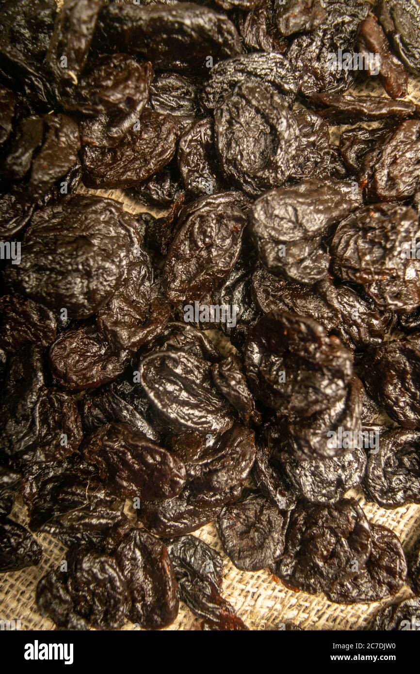 Dried prunes in bulk on burlap with a rough texture. Close up Stock ...