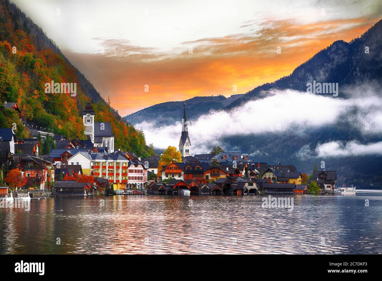 Scenic view of famous Hallstatt mountain village with Hallstatter lake. Foggy autumn sunrise on ...