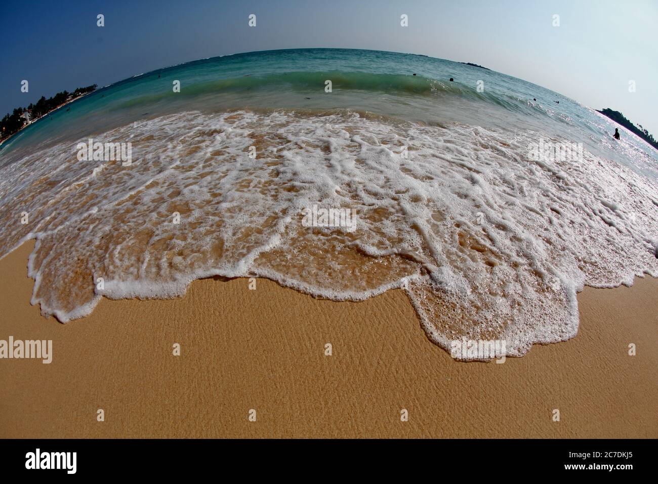 Horizontal shot of the beach and the sea waves under the blue sky Stock ...