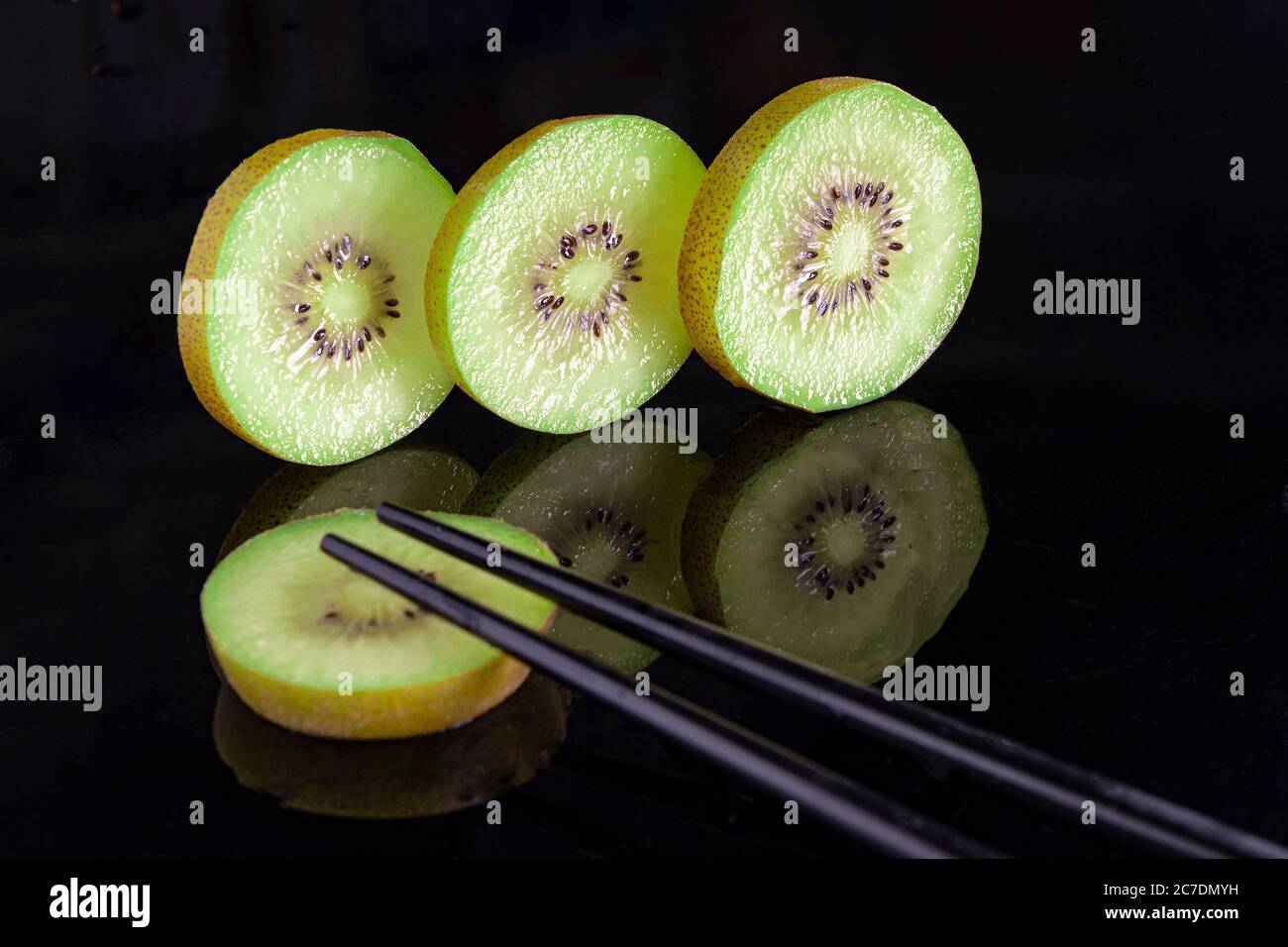 Kiwi one piece sliced and three pieces chopped stand and next to ...