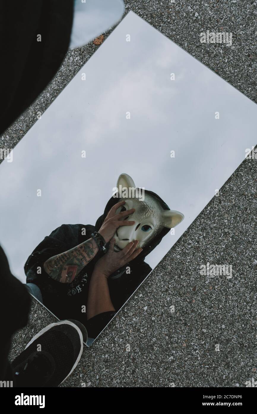 black hooded surprised person wearing sheep mask looking at his ...