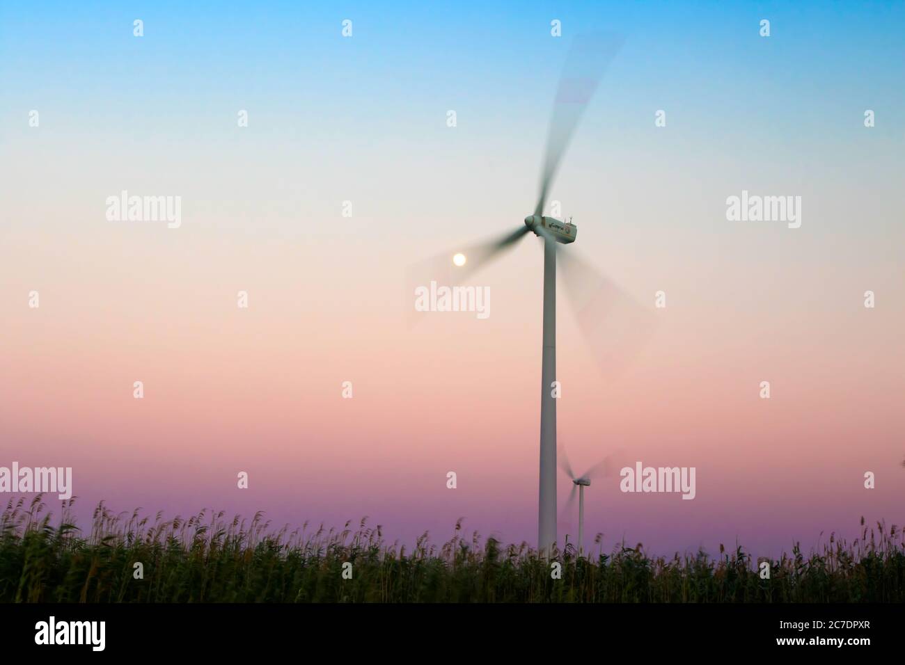 Wind turbine and sunset sky background Stock Photo - Alamy