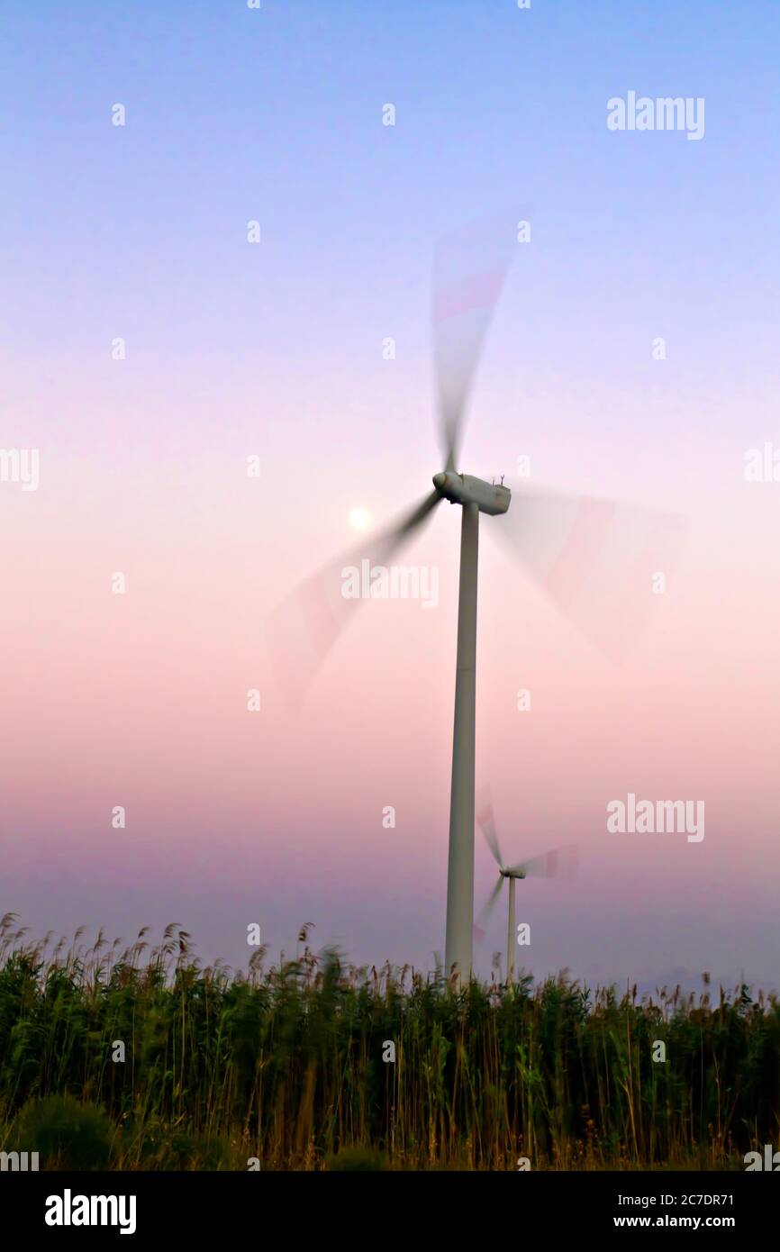 Wind turbine and sunset sky background Stock Photo - Alamy