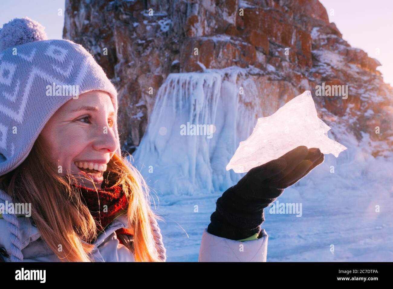 Traveling woman with block of ice gleaming in the sun. Winter tourism ...
