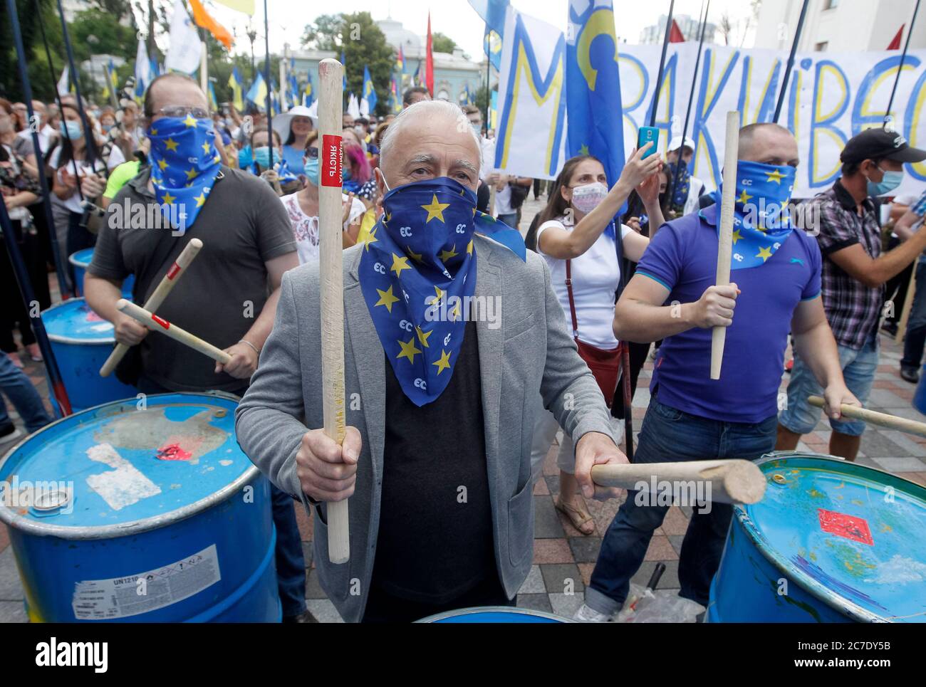 Kiev, Ukraine. 16th July, 2020. Men wearing masks make sound by hitting ...
