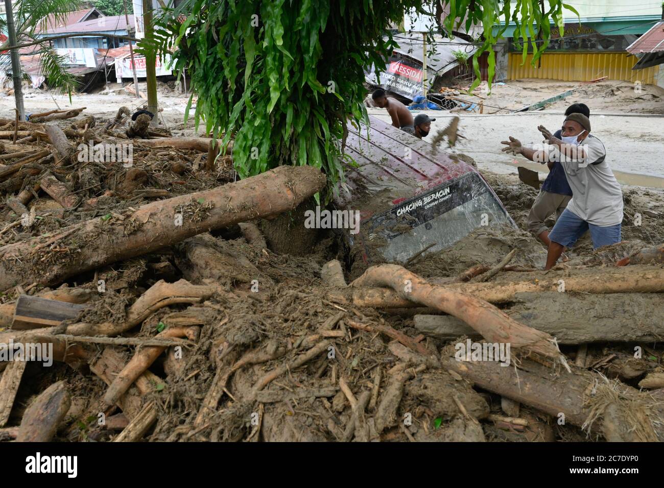Masamba, Indonesia. 16th July, 2020. Residents try digging up a vehicle ...