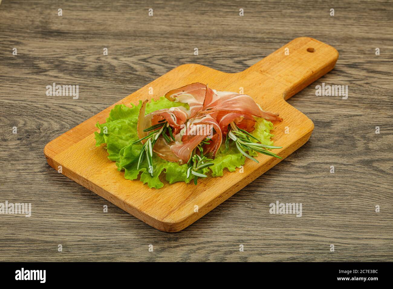 Sliced pork Jamon meat with rosemary Stock Photo - Alamy