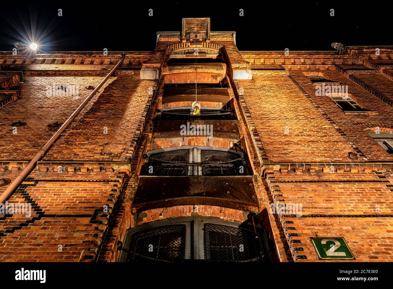 Low angle shot of a brick building with a metal hook hanging from the ...