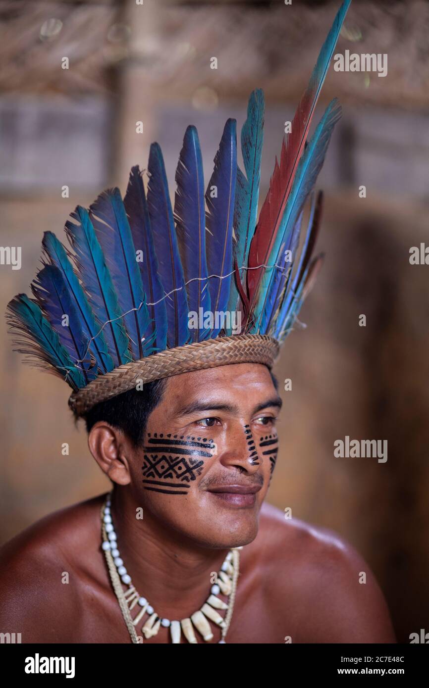 Tribal leader with a feather crown and bone necklace Stock Photo - Alamy