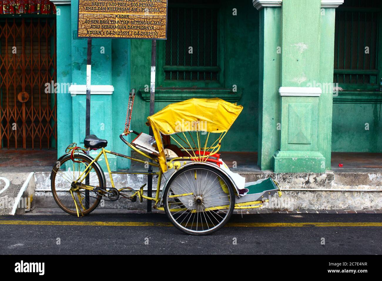 Horizontal shot of a yellow cycle rickshaw in Georgetown, Malaysia ...