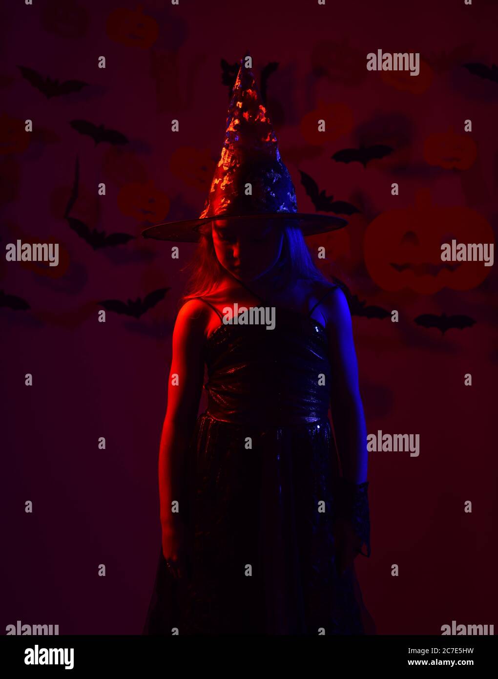 Girl with sad face on bloody red background with bats and pumpkins ...